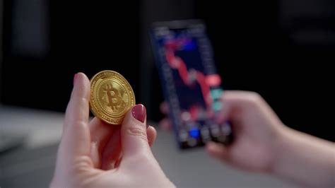 Female Fingers Holding Golden Bitcoin Watching Crypto Trading Investment Chart Decline On