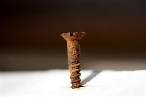 Premium Photo Close Up Of Rusty Screw In Table