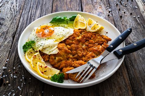 나무 테이블에 계란 프라이와 레몬을 곁들인 바삭한 빵가루 입힌 그을린 치킨 커틀릿 0명에 대한 스톡 사진 및 기타 이미지 0명 감자 요리 겉만 태우기 Istock