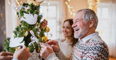 크리스마스에 집에서 실내에 있는 쾌활한 다세대 가족 트리를 장식합니다 사진 Unsplash의 성숙한 성인 이미지