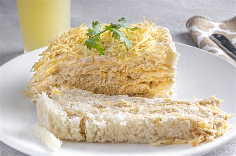 전형적인 브라질 요리 인 차가운 짭짤한 치킨 파이 조각을 자릅니다 빨간색 모양 회색 나무 배경 흰색 접시 옆에는 나무 숟가락 칼 붙이 및 캐슈 주스가 있습니다 갈색에 대한