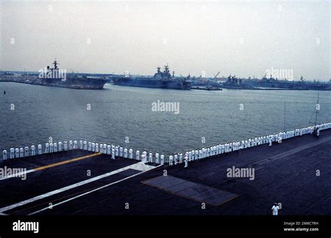 sailors line the edge of the flight deck as the aircraft carrier uss coral sea cv 43 returns