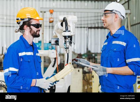 Engineer Controlling Robot Arm At Factory Checking The Operation Of Robot Arm Technology