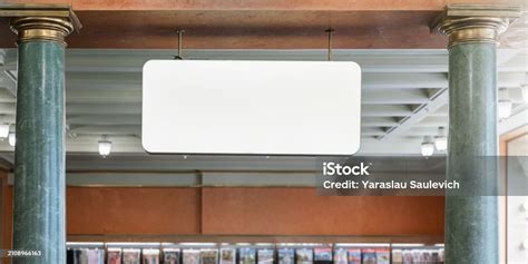 클래식 기둥과 잡지 선반을 배경으로 빈티지 상점 내부에 매달린 빈 간판 매장 내 브랜딩 제안 및 소매 환경의 탐색 간판에 이상적입니다 표지판에 대한 스톡 사진 및 기타