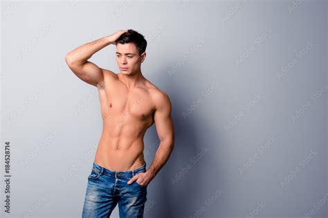 Sexy Handsome Virile Confident Srtong Muscular Man Is Combing His Hair He Is Isolated On Grey