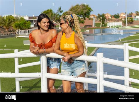 A Loving Mother And Her Transgender Daughter Share A Joyful Moment While Leaning On A White