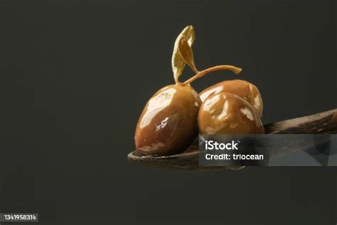 엑스트라 버진 올리브 오일은 검은 색 배경에 녹색 올리브로 가득 한 나무 숟가락에 흐릅니다 0명에 대한 스톡 사진 및 기타 이미지 Istock