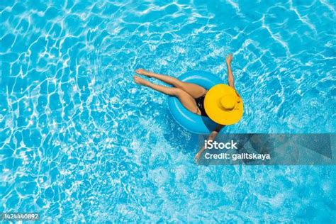 반지 수영장의 수영장에 앉아있는 여성이 큰 노란색 선햇에 떠 있습니다 목욕하기에 대한 스톡 사진 및 기타 이미지 목욕하기 수영장 스포츠 경기장 여름 Istock
