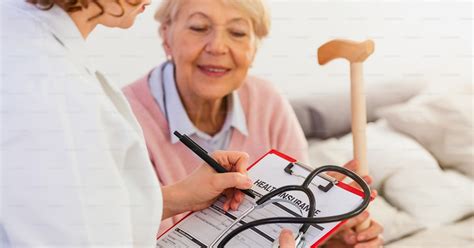 노인 여성은 의사 또는 간병인이 방문합니다 여성 의사 또는 간호사가 노인 환자와 이야기합니다 의학 나이 건강 관리 및