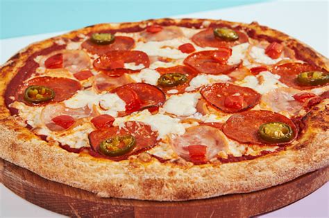 햄 페퍼로니 할라페노를 색칠한 배경에 곁들인 이탈리아 피자 살라미와 칠리 후추를 곁들인 고기 피자는 파란색으로 최소한의 스타일로 제공됩니다 컬러 배경을 가진 미국 피자 배달