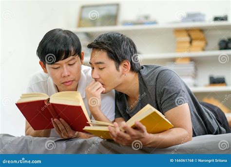 亚洲同性恋夫妇在他们家的阅览室里一起读了一些书，他们看起来很幸福 库存照片 图片 包括有 教育 户内 166061768