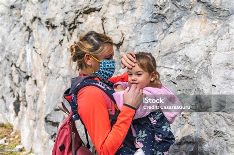 딸과 함께 하이킹 할 때 아기 캐리어를 사용하여 보호 얼굴 마스크를 가진 어머니 18 23 개월에 대한 스톡 사진 및 기타 이미지 18 23 개월 2명 35 39세