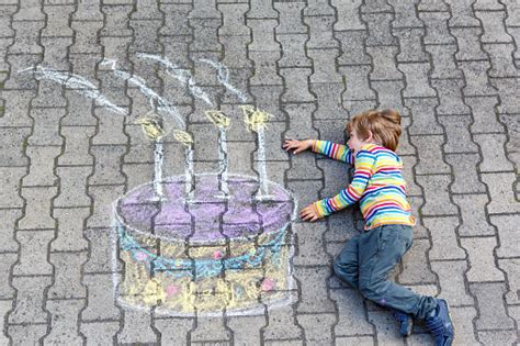 화려한 분필로 큰 생일 케이크 그림 그리기로 재미있게 지내는 행복한 어린 아이 소년 여름철 야외 어린이를위한 창조적 인 여가 활동 생일을 축하하고 땅에 그림을 그리는 어린이
