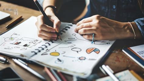 A Person Sketching Business Ideas And Strategies On A Notepad