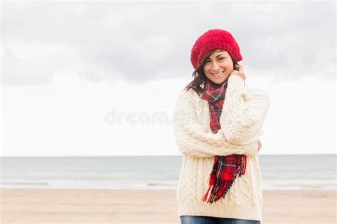 Милая усмехаясь женщина в стильной теплой одежде на пляже Стоковое Изображение изображение