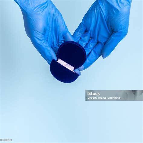 파란색 선물 상자는 파란색 배경에 파란색 의료 장갑을 끼고 남자의 손에 비어 복사 공간 사각형 12월에 대한 스톡 사진 및 기타 이미지 Istock