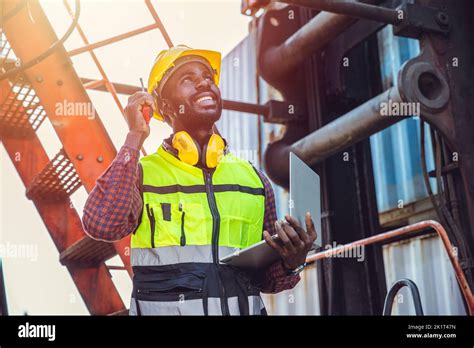 black african male worker working in port cargo radio control loading container in logistic