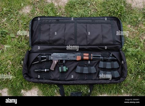 Uncovered Gun Case With Ak 47 Magazines And Flashlight Lying On The