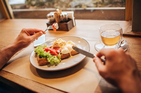 포크와 나이프를 들고 남자의 손의 닫습니다 야채와 함께 맛 있는 와플의 접시와 차 한 잔이 있다 테이블 창 앞에 서 서 경외감에 대한 스톡 사진 및 기타 이미지 Istock