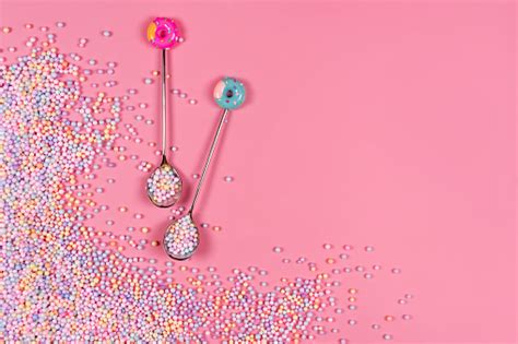 카피 스페이스와 분홍색 배경에 숟가락파스텔 색상 설탕 공의 더미 과자 장식을위한 혼합 다채로운 사탕 무지개 색설탕 사탕 드라기