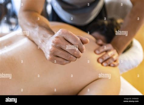 A Strong Male Massage Therapist Giving A Man A Deep Tissue Massage