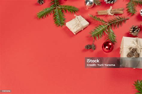 크리스마스 또는 겨울 구성 파스텔 레드 배경에 전나무 나뭇 가지 소나무와 계피의 공예 종이로 장식 된 수제 선물 상자 플랫 레이 상단 보기 복사 공간 가문비나무에 대한 스톡