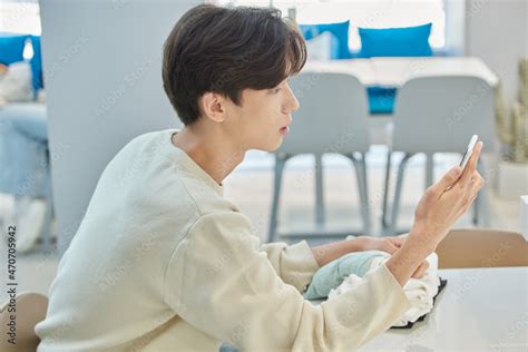 Foto De 셀프 세탁실에서 세탁기 또는 건조기 앞에서 세탁물을 손을 들고 있는 아시아 한국 남자 모델 부분 클로즈업 Do Stock Adobe Stock