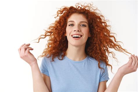 Mulher Caucasiana Ruiva Atraente Confiante Com Olhos Azuis Tocando Cachos Rindo E Sorrindo