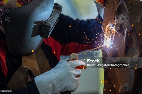 산업 용접기 노동자 금속 용접 강철은 공장 금속 세공 제조 및 건설 유지 보수에서 강철을 용접하기 위해 전기 아크 용접기를 사용하여 작동합니다 50 54세에 대한 스톡 사진