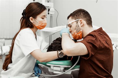 젊은 남성 치과 의사가 환자를 치료합니다 치과 수술에서 의학 조작 전문 유니폼과 치과 의사의 장비 의료 는 의사 작업장 장착 치과 3 명에 대한 스톡 사진 및 기타 이미지