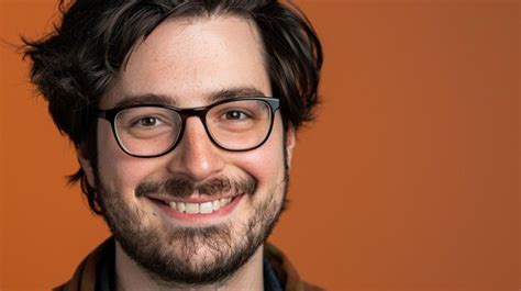 A Man With Glasses And A Brown Shirt Is Smiling Premium Ai Generated