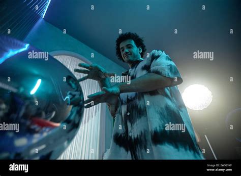 Low Angle Shot Of Stylish Man Posing Next To Shiny Art Object Moving