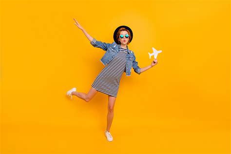 전체 길이 몸 크기 사진 아름 다운 여우 그녀 그녀의 숙 녀 종이 비행기 여행자 척 비행 착용 사양 빈티지 모자 캐주얼 스트라이프 T 셔츠 드레스 청바지 데님 고립 된