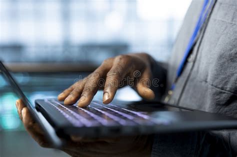 employee in data center typing on laptop keyboard analyzing metrics