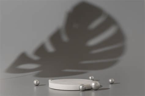 회색 배경에 은진주가 달린 흰색 대리석 연단과 열대 식물의 그림자 제품 화장품 프리젠 테이션연단 창조적 인 조롱 미용 제품을