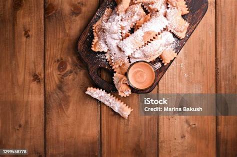 카니발 음식 전형적인 향기로운 커피 나무 배경에 스프라폴 또는 치아치에 또는 천사 날개 전통적인 달콤한 바삭바삭한 페이스트리 튀김과 가루 설탕을 뿌립니다 0명에 대한 스톡