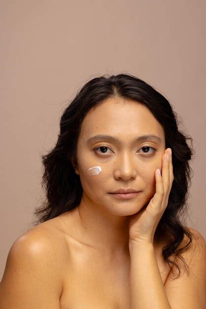 Premium Photo Asian Woman With Dark Hair With Skin Cream On Her Cheek