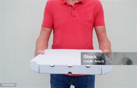 피자 배달 빨간 폴로를 입은 택배기사가 피자가 든 골판지 상자를 들고 있습니다 피자 배달원이 상자를 들고 있습니다 피자 배달부에 대한 스톡 사진 및 기타 이미지 Istock