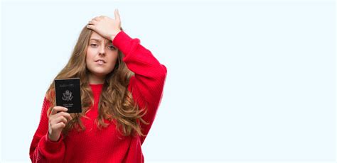 젊은 금발 여 자가 미국 손으로 머리에 강조의 여권 들고 충격 수치심과 깜짝 얼굴로 분노와 좌절 두려워 하 고 실수에 대 한