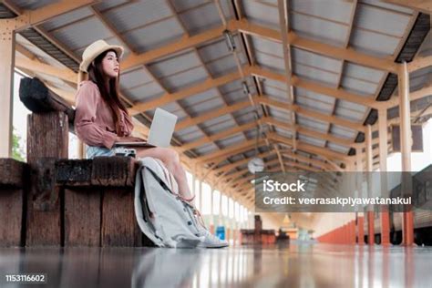 기차역에서 휴가 휴식을 계획하는 노트북을 사용하여 배낭을 가진 미소 하는 여자 여행자 휴식 개념 여행 개념n 가방에 대한 스톡 사진 및 기타 이미지 Istock