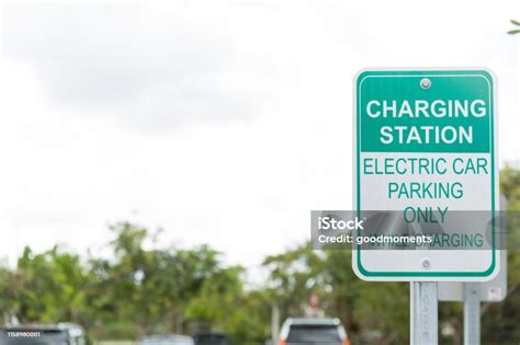 전자 차량 충전 스테이션은 부분적으로 흐린 하늘과 녹색 나무에 대한 기호 흰색과 청록색 색상 배경에 Ev 충전 스테이션 표지판 도로 표지판 표지판에 대한 스톡 사진 및 기타