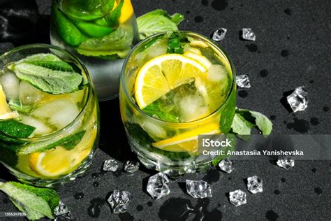 모히토 상쾌한 칵테일 알코올 음료 레몬과 민트 잎이 어두운 배경에 레모네이드 얼음 조각 여름 상쾌한 해독 음료 깨끗한 식사 건강한 라이프 스타일 컨셉 0명에 대한 스톡 사진