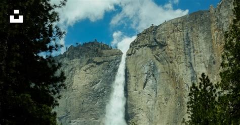 나무가 우거진 숲 위로 우뚝 솟은 높은 폭포 사진 Unsplash의 무료 요세미티 폭포 이미지