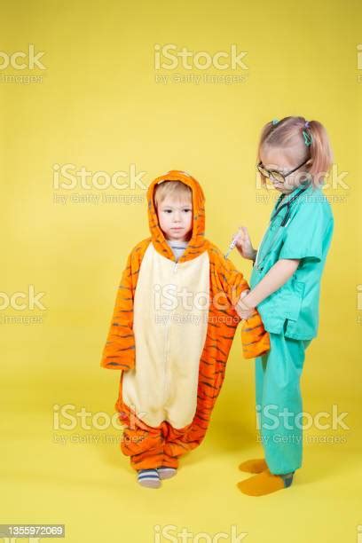 아이들은 의사를 재생 의사로 옷을 입은 소녀는 호랑이로 옷을 입고 소년에 주사를 제공합니다 2 3 살에 대한 스톡 사진 및 기타 이미지 Istock