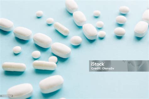 파란색 테이블에 흰색 알약 의료 약국 및 의료 개념 공간을 복사합니다 텍스트 또는 로고를위한 공간 광고 또는 기타 아이디어로 특별 제안을위한 모형 0명에 대한 스톡 사진 및