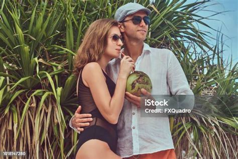 매력적인 커플 보유 코코넛 팜 부시 근처 해변에서 포즈를 취하는 튜브와 함께 아름 다운 섬에 휴가 즐긴다 경관에 대한 스톡 사진 및 기타 이미지 Istock