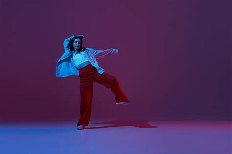 유연한 어린 소녀 힙합 춤을 추는 현대 댄서 또는 네온의 어두운 보라색 배경에 고립된 실험적인 춤 현대 무용 음악 댄스 액티브 라이프 스타일 패션 스타일 20 24세에 대한