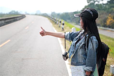Premium Photo Woman Hitchhiking On Road