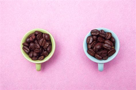 유토이미지 분홍색 배경 위의 귀여운 컵에 담겨져 있는 커피 원두