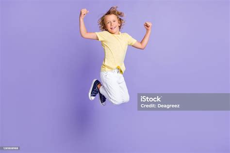 포지티브 보이 점프 쇼 이두근의 전체 길이 사진은 보라색 색상 배경에 고립 된 흰색 노란색 티셔츠 바지를 착용 아이에 대한 스톡 사진 및 기타 이미지 Istock